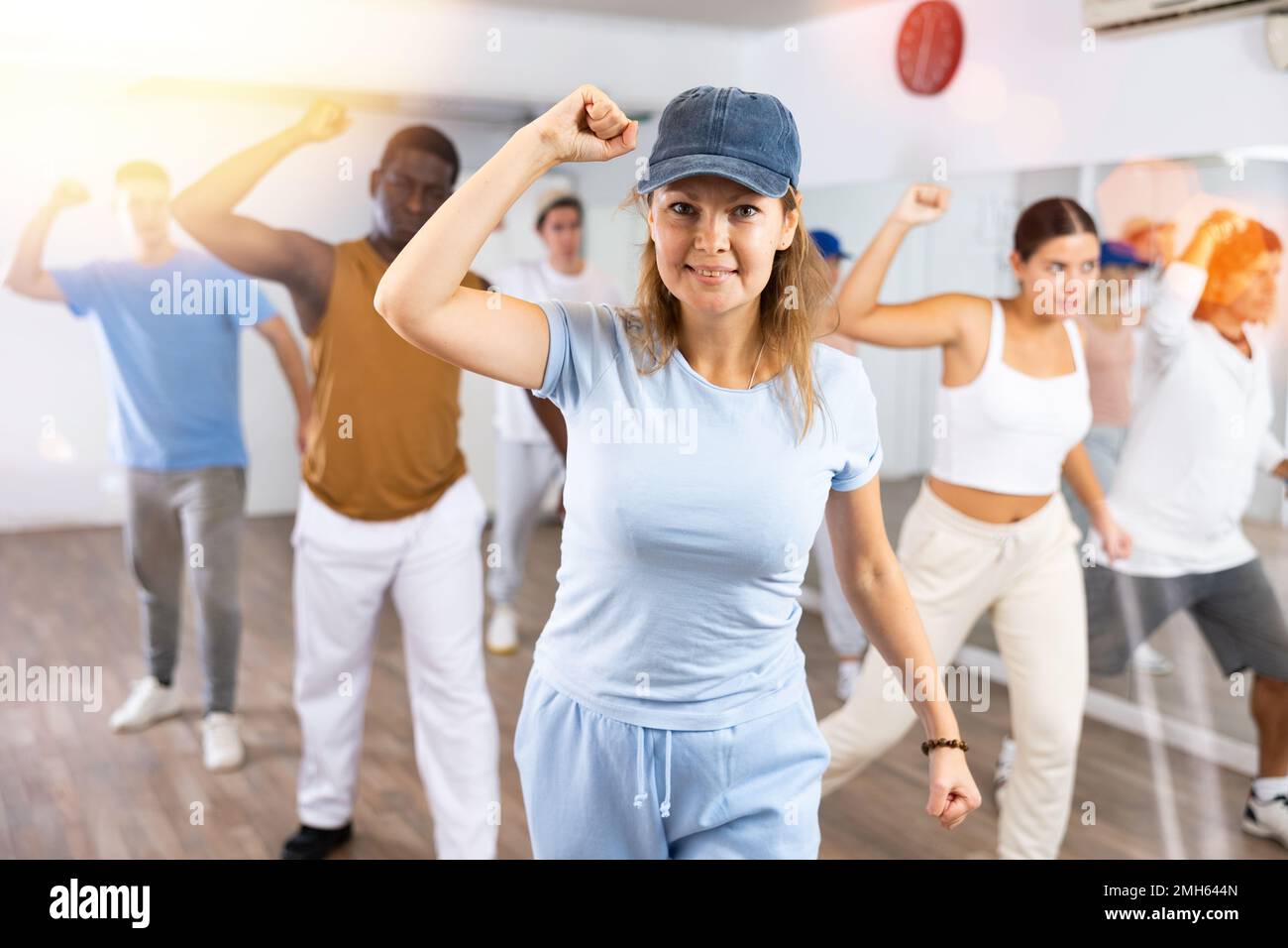 Group of active women and men practicing energetic dance in modern ...