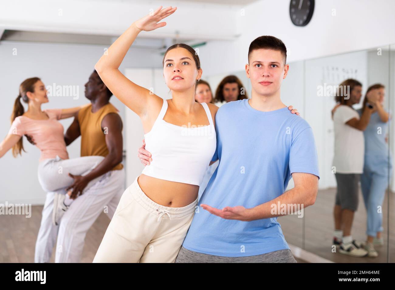 Group of excited young adult people dancing dynamic moves in pairs ...