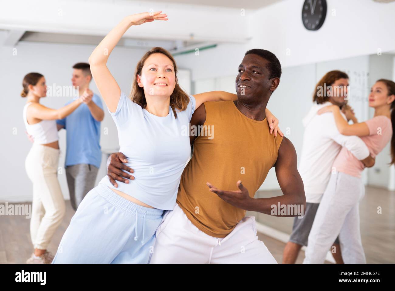 Woman and man practicing bachata dance moves in pair during group ...