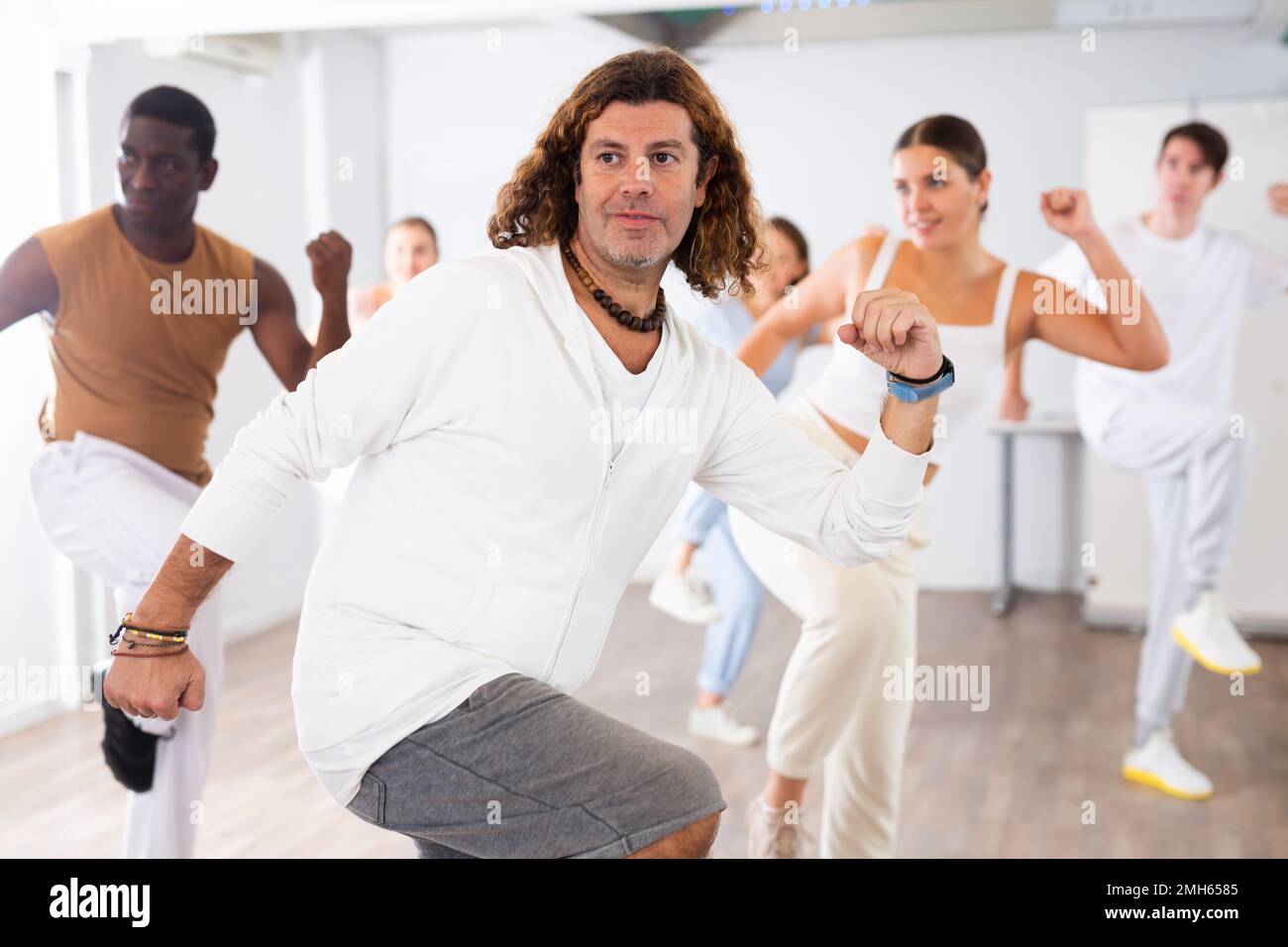 Cheerful energetic multiracial dancers of different ages dancing ...