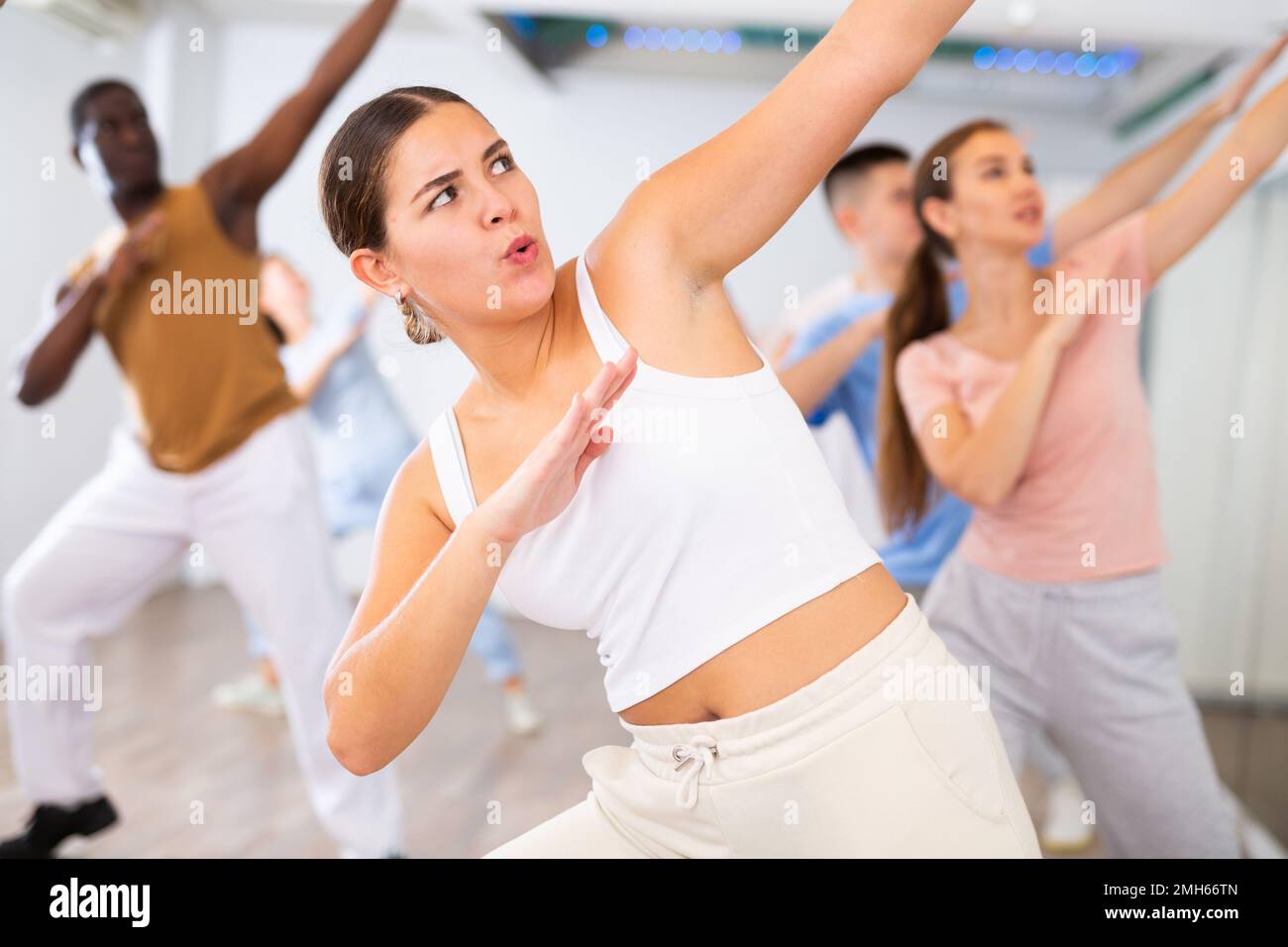 Group of sporty young adult multinational sports people making straight ...