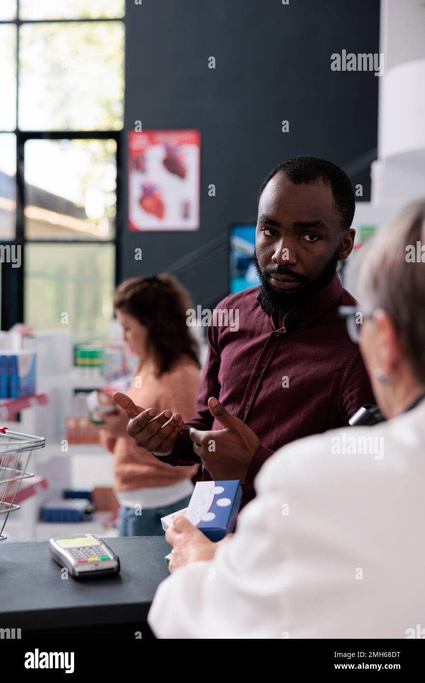 African american client asking pharmacist for help with medicaments ...