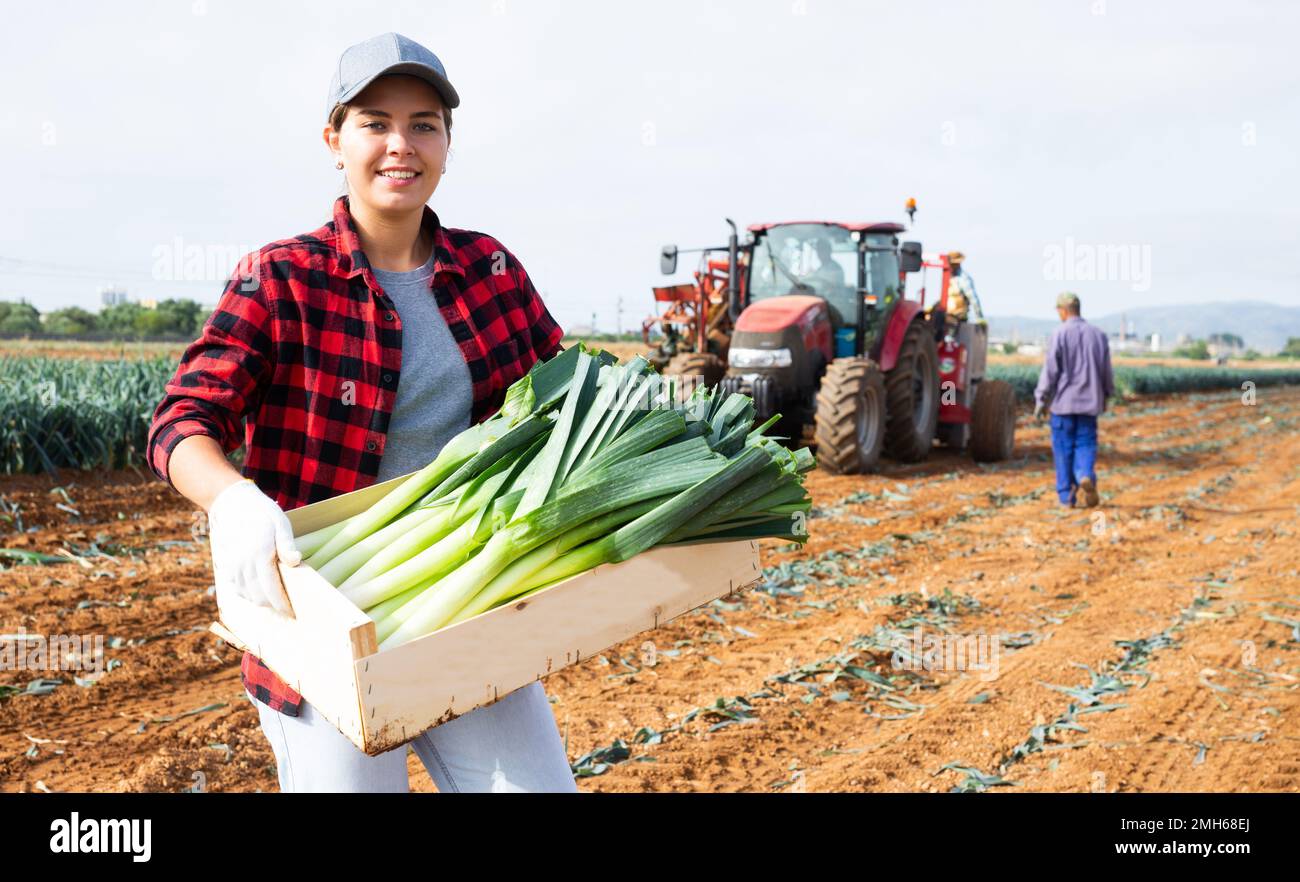 Woman posing with leek crop on field Stock Photo - Alamy