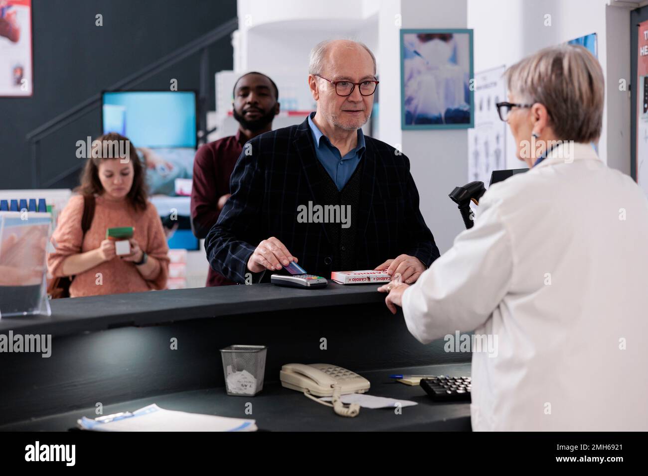 Elderly customer paying pharmaceutics pills with credit card using ...