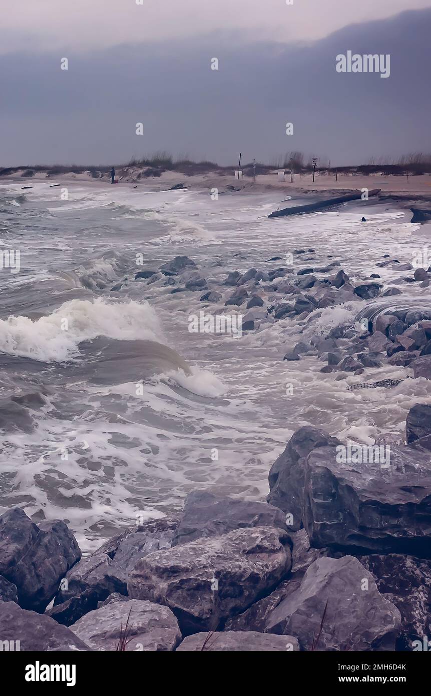 Waves crash on a nearly deserted winter beach at Dauphin Island West ...