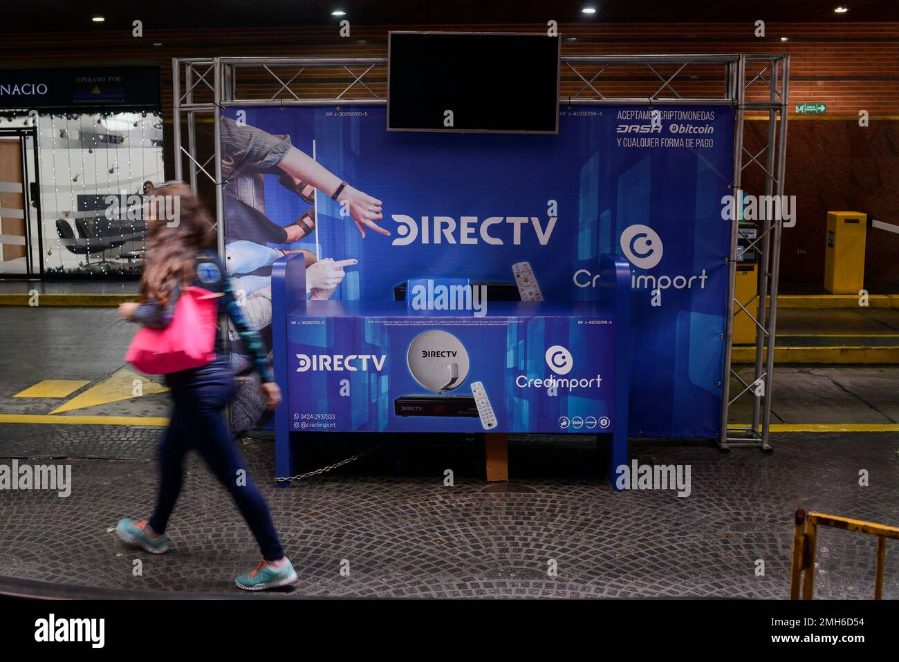 A woman walks past a DirecTV store at the San Ignacio shopping center ...