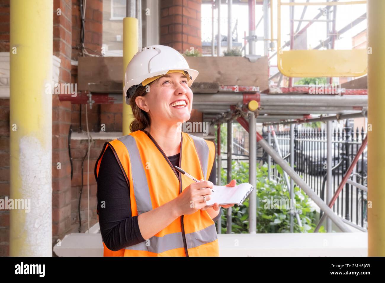 Laughing civil engineer woman surveying and supervising a construction ...