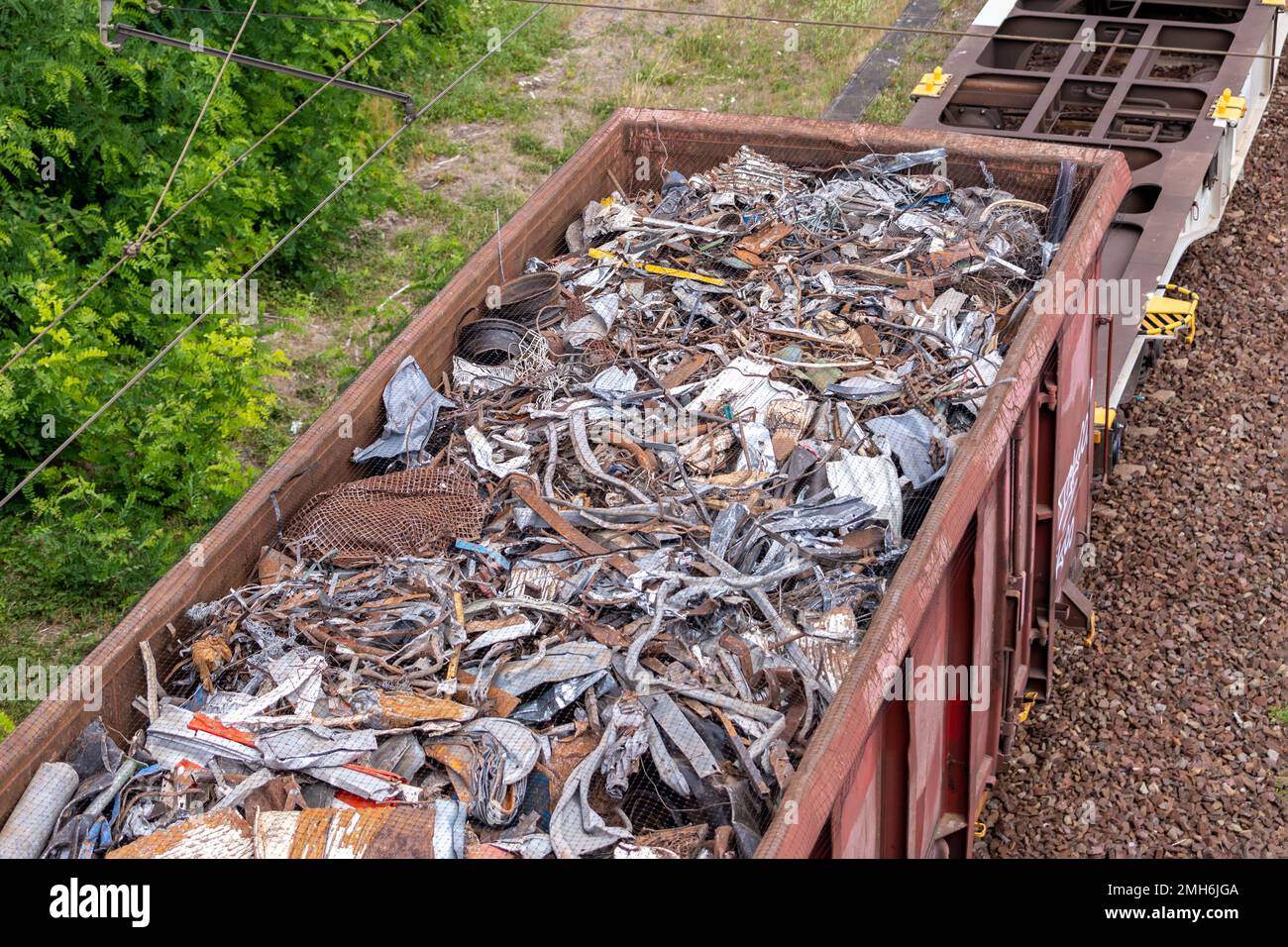 Above view of railway cargo train wagon filled by old rusty black metal ...