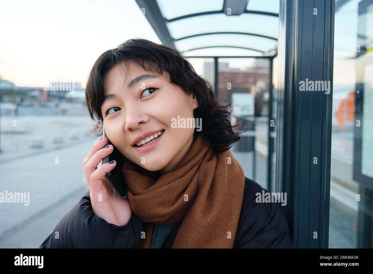 Close up of cute Korean woman, making a phone call, talking and smiling ...