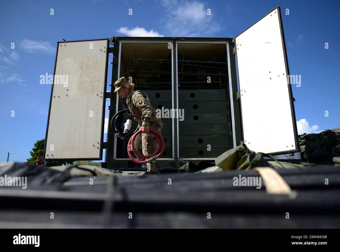 A member of the US army reserve works to set up up portable showers in ...