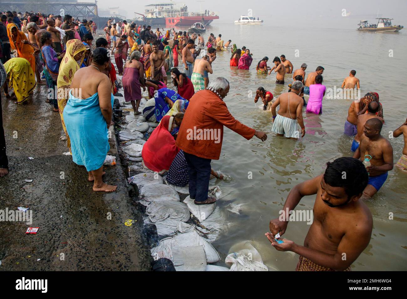 Hindu devotees take holy dips on the bank of the Hooghly River on the ...