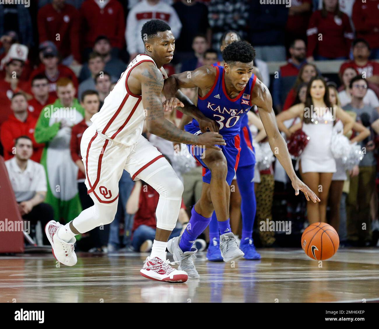 Kansas' Ochai Agbaji (30) drives the ball against Oklahoma's Kristian ...