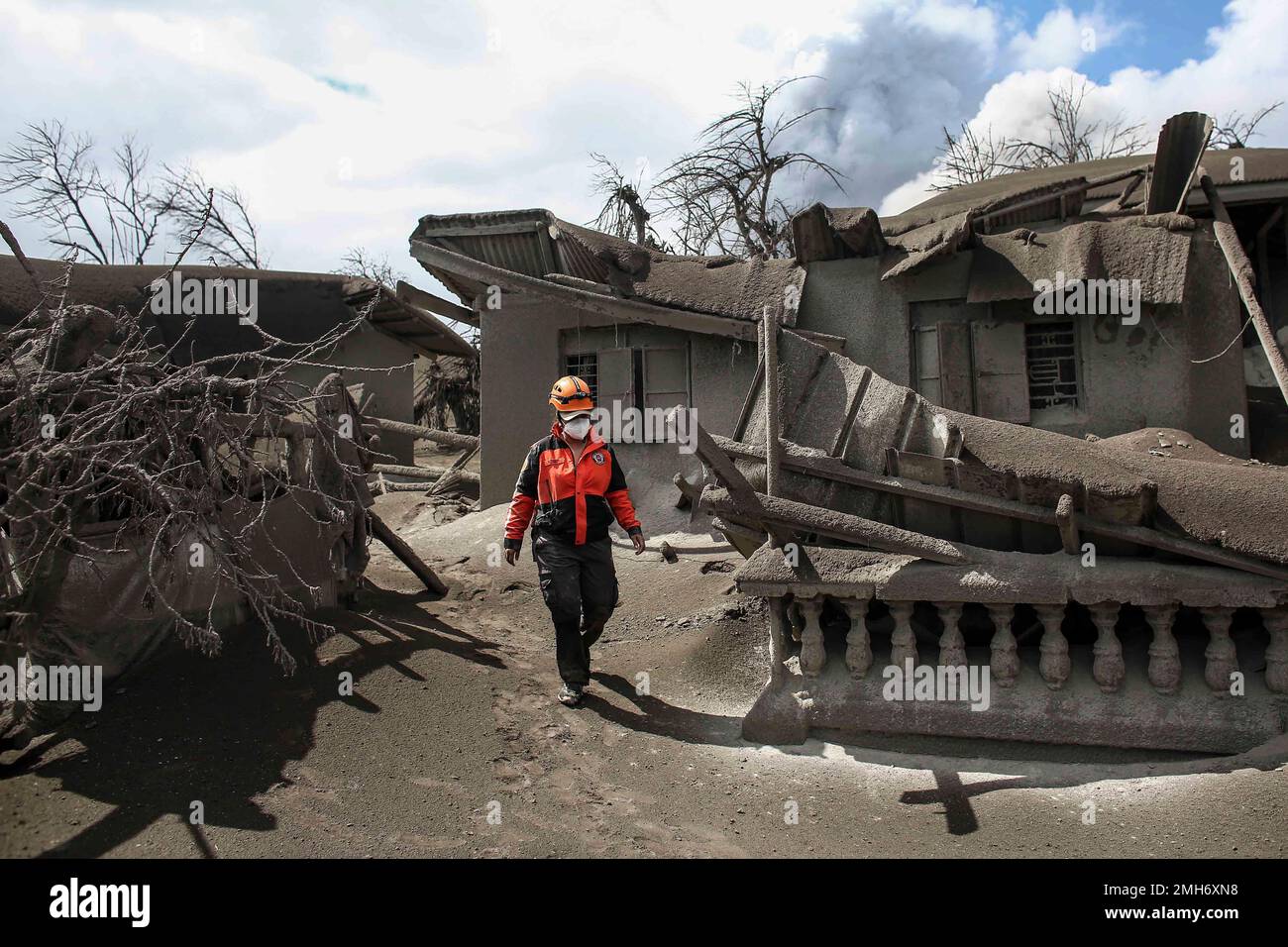 In this Jan. 14, 2020, photo, a rescue volunteer walk on the Taal volcano island beside damaged ...