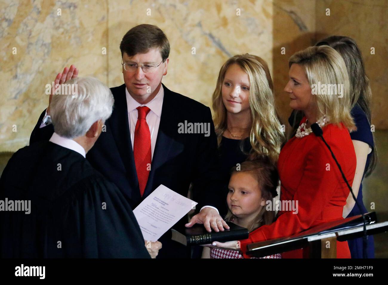 Gov. Tate Reeves, center, recites the oath of office, as administered ...