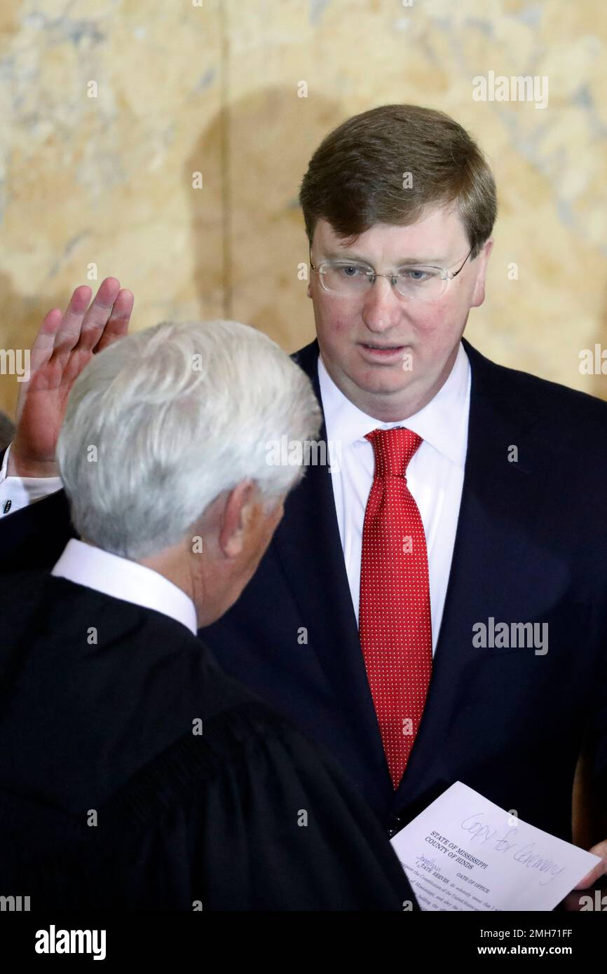 Gov. Tate Reeves, right, recites the oath of office, as administered to ...