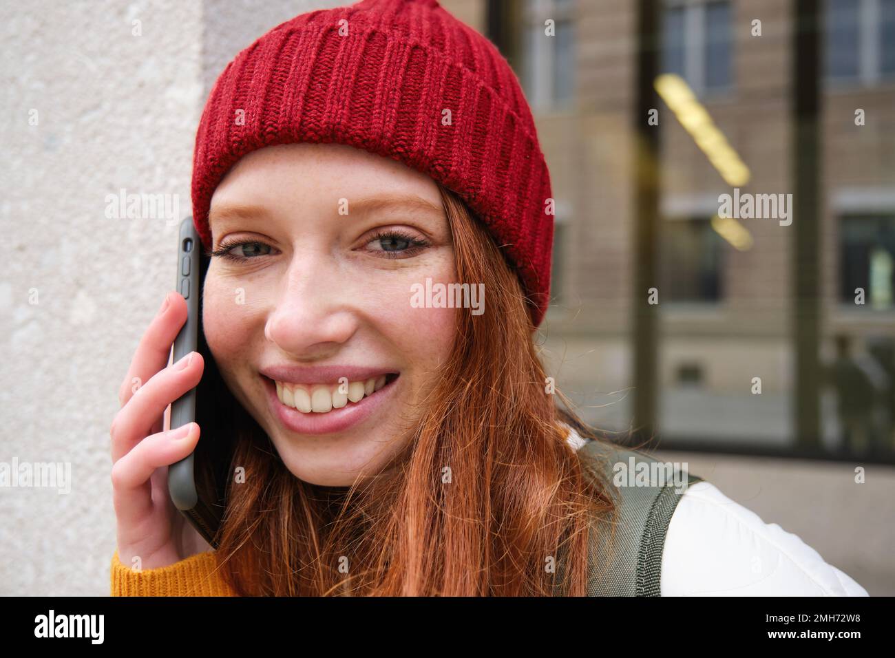 Young people and mobile connection. Happy redhead girl talks on phone ...