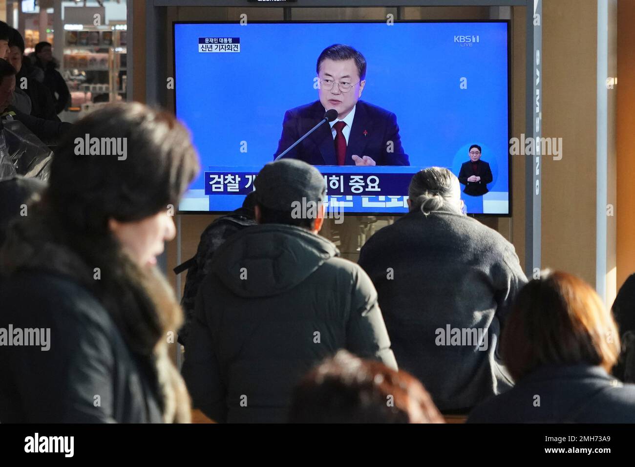 People watch a TV screen showing the live broadcast of South Korean ...