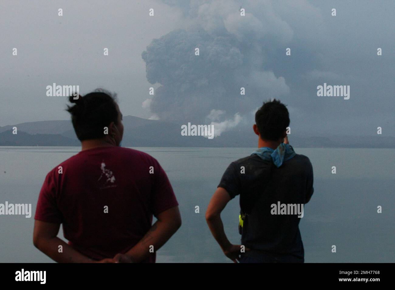 Residents watch Taal volcano spew ash from a look out in Talisay ...