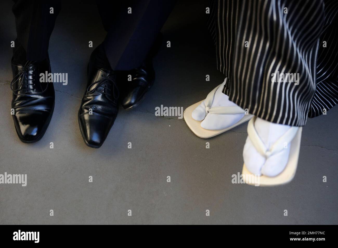 A man wearing traditional Japanese sandals called geta attends a Coming ...