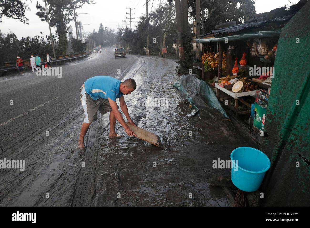 Residents cleans ash fall from Taal Volcano's eruption Monday Jan. 13 ...
