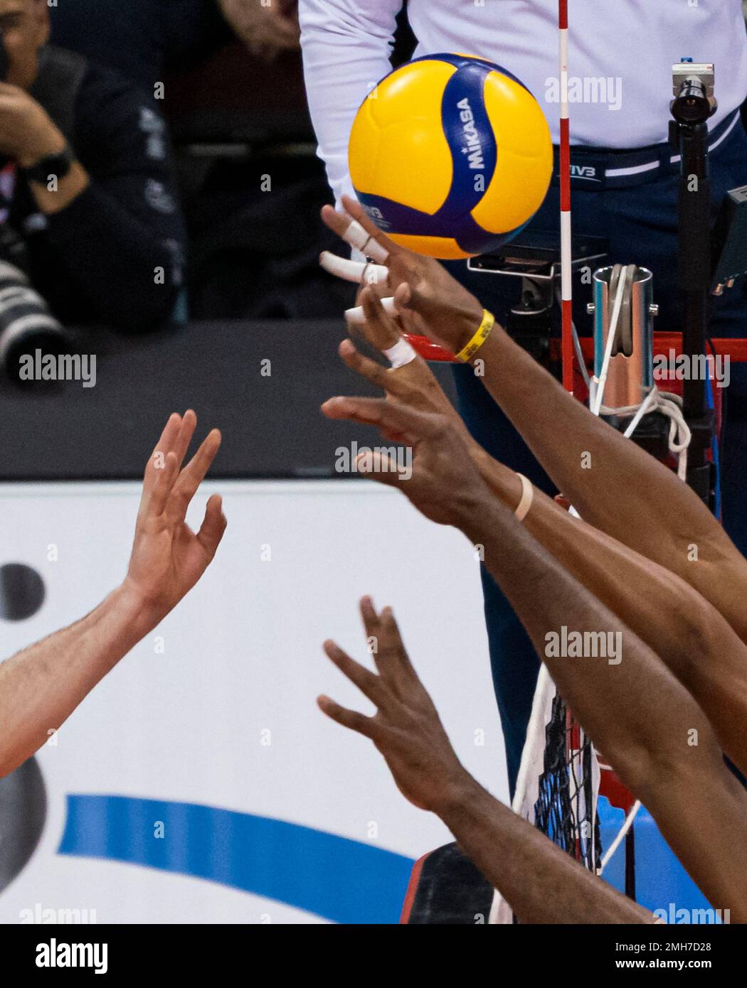 Canada's Nicholas Hoag, left, tips the ball over the block of Cuba ...