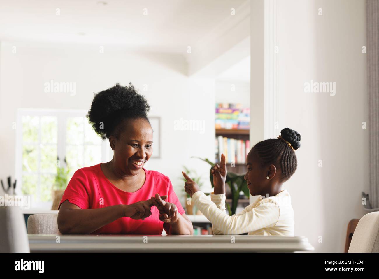 Happy african american grandmother and deaf granddaughter using sign ...