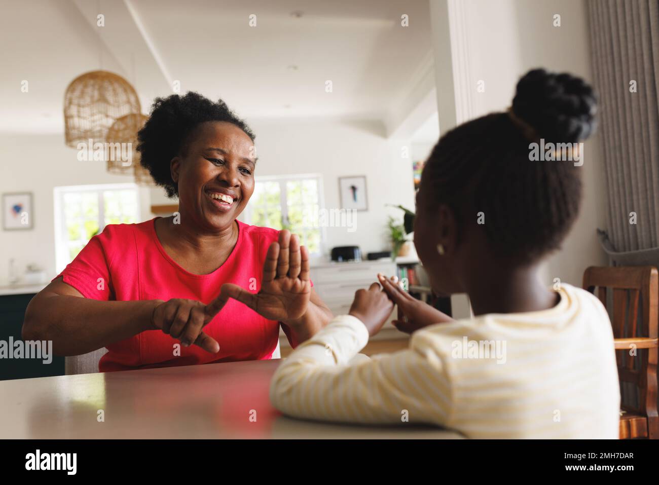 Happy african american grandmother and deaf granddaughter using sign ...