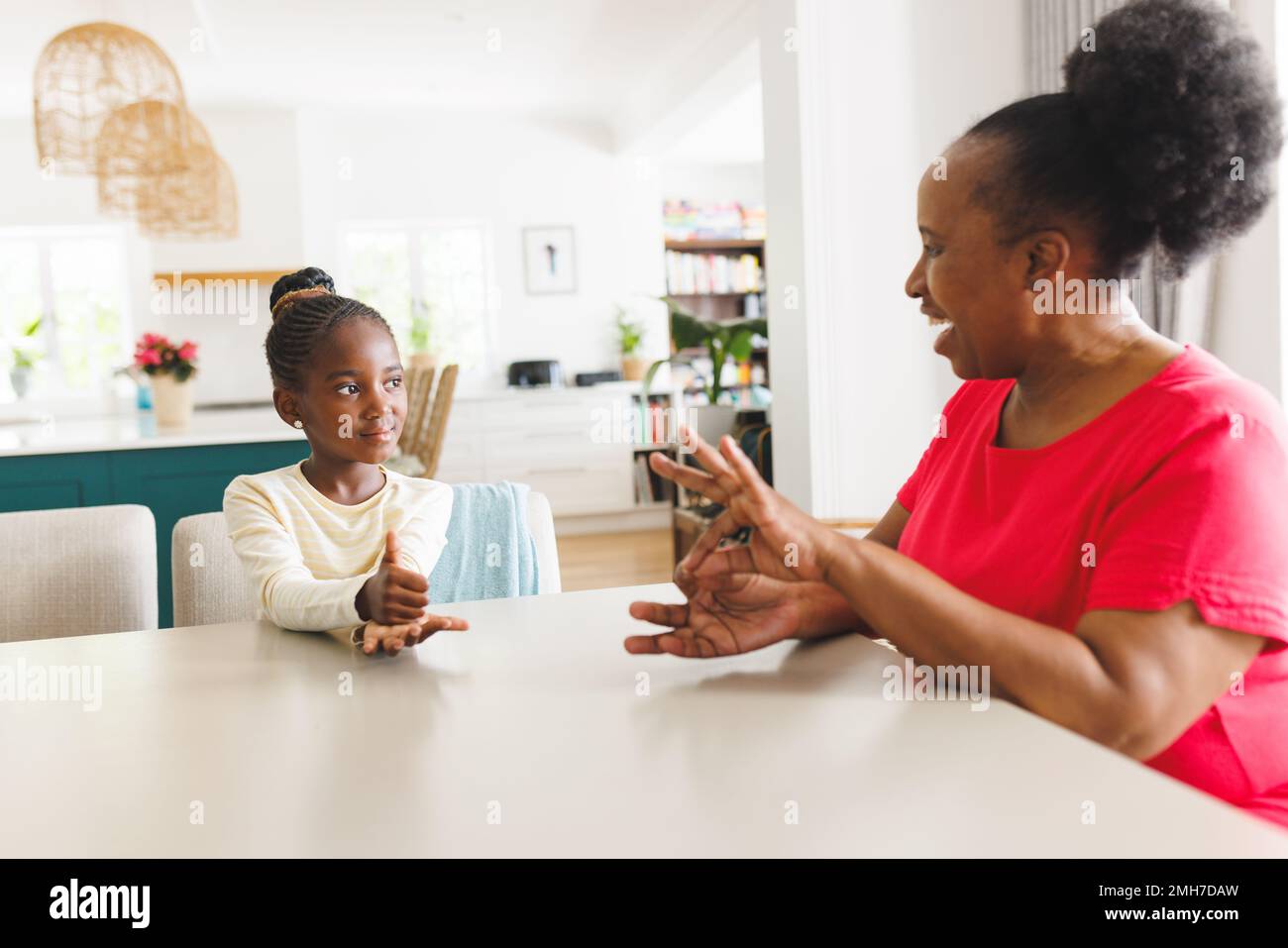 Happy african american grandmother and deaf granddaughter using sign ...