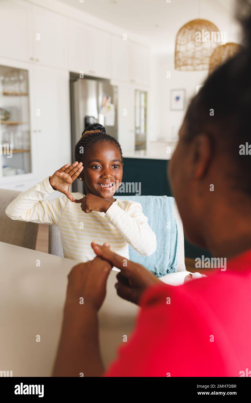 Happy african american grandmother and deaf granddaughter using sign ...