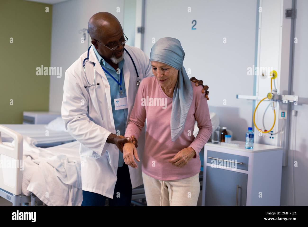 African american male doctor visitng senior caucasian female cancer ...