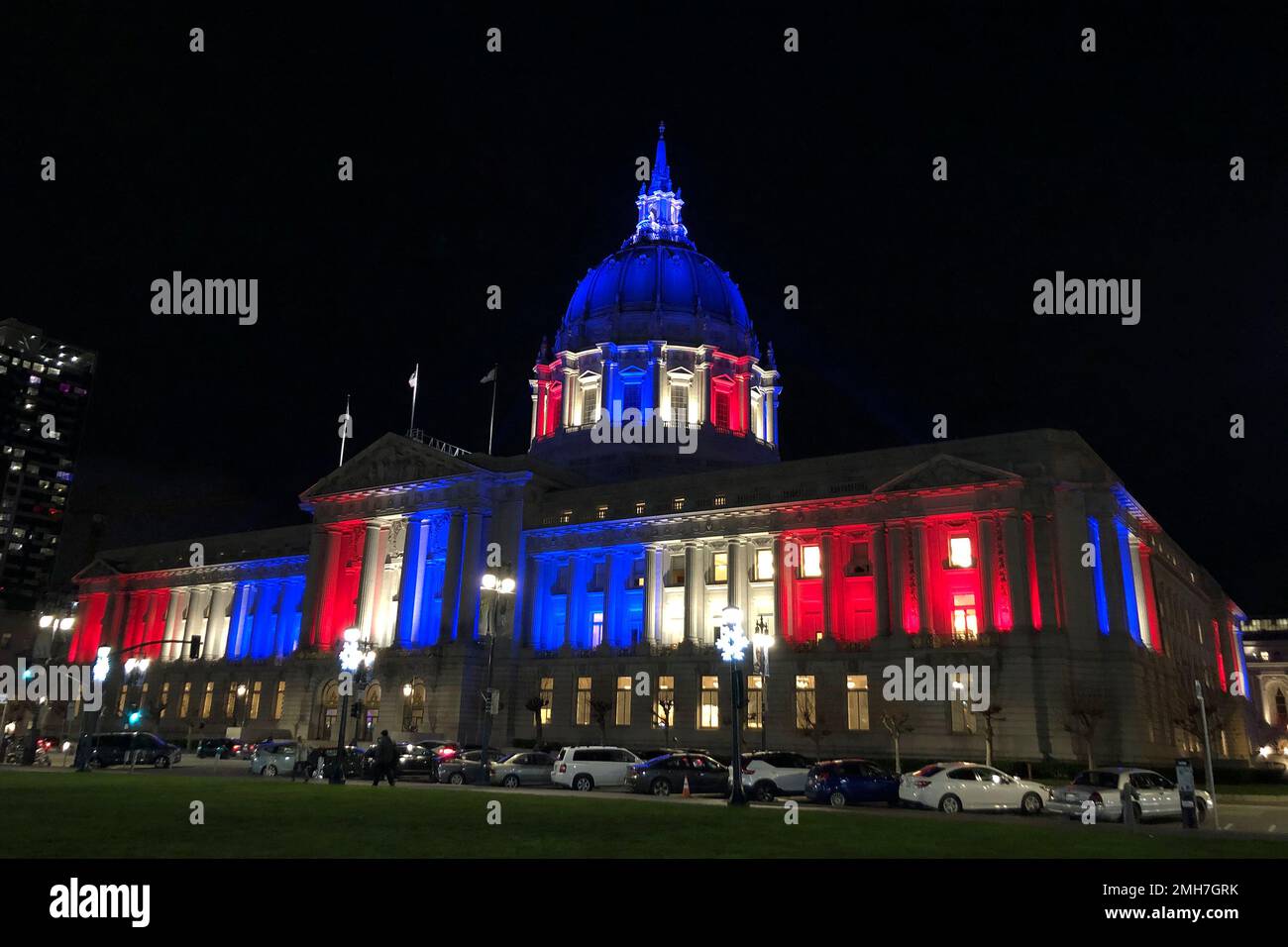 The City Hall building is shown illuminated with red, white and blue ...