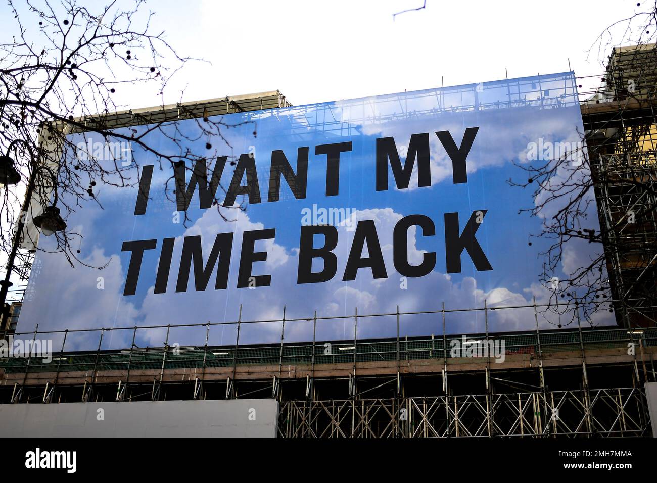 A banner reading 'I want my time back' is seen on the facade of ...