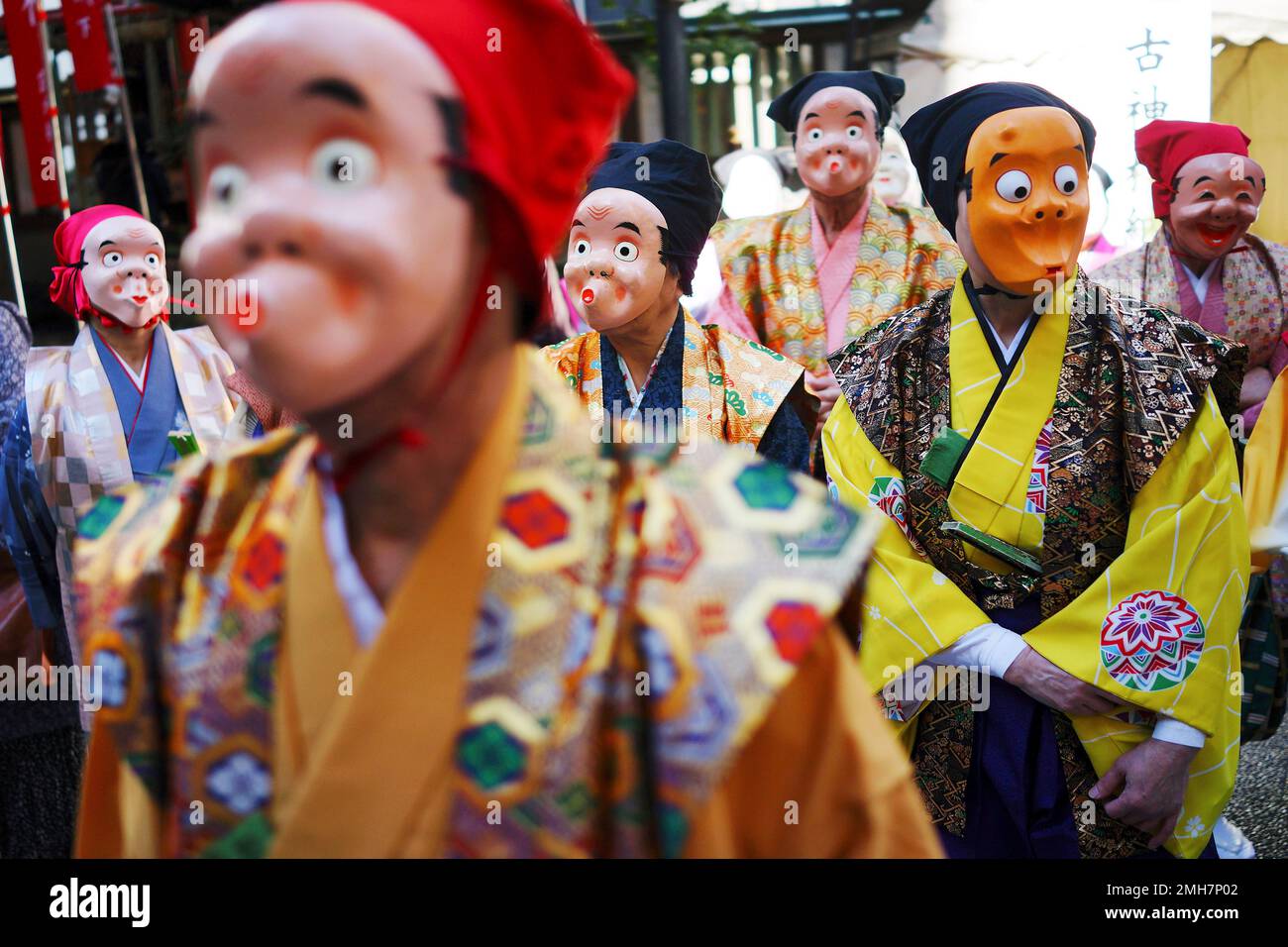Artists wearing Japanese traditional clown masks stand for marching ...