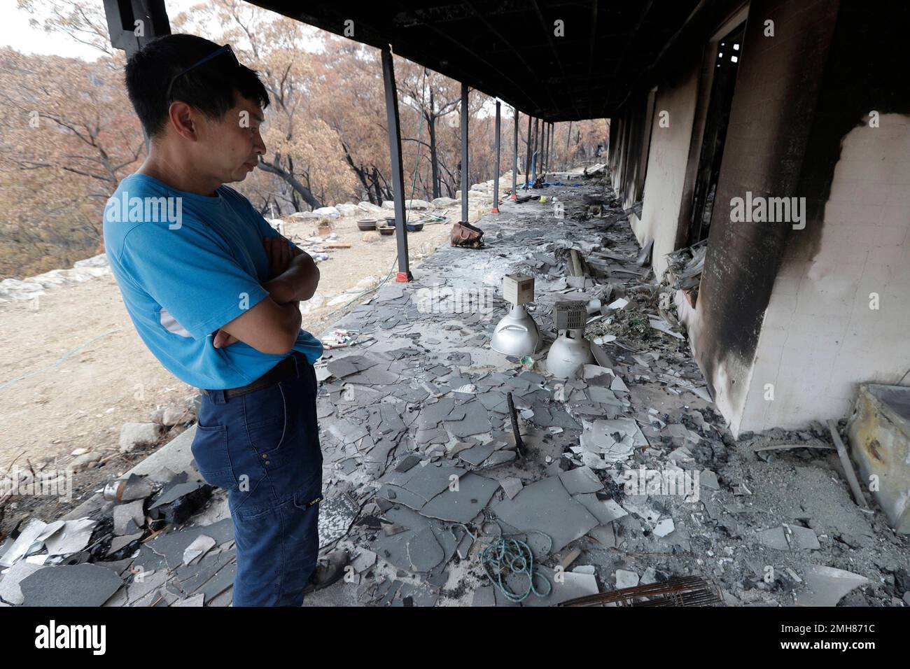 Justin Kam surveys his destroyed home at Balmoral, Australia, Tuesday ...