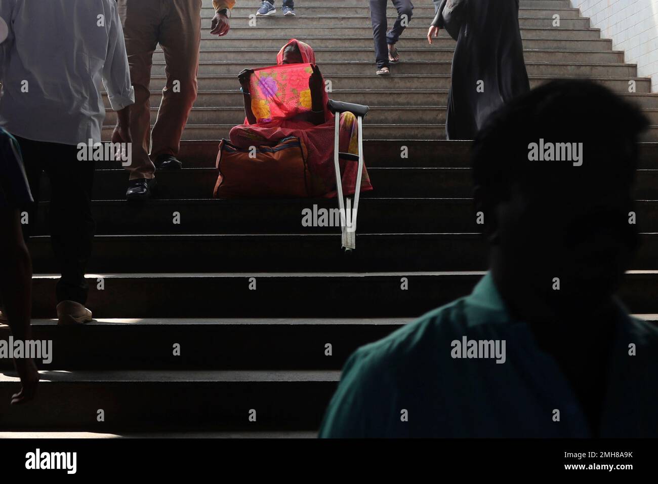 An Indian woman seeks alms from commuters outside the Chhatrapati ...