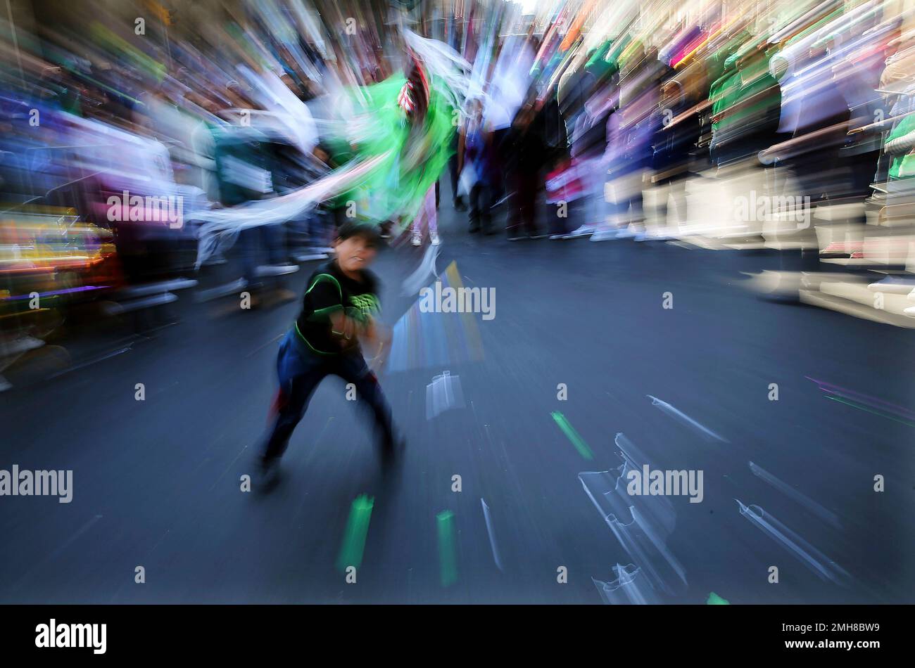 A boy hits a traditional Christmas “pinata” filled with fruit and candy ...