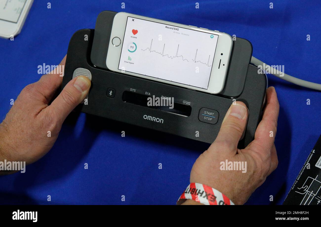 A man demonstrates the Omron Complete blood pressure monitor and EKG at ...