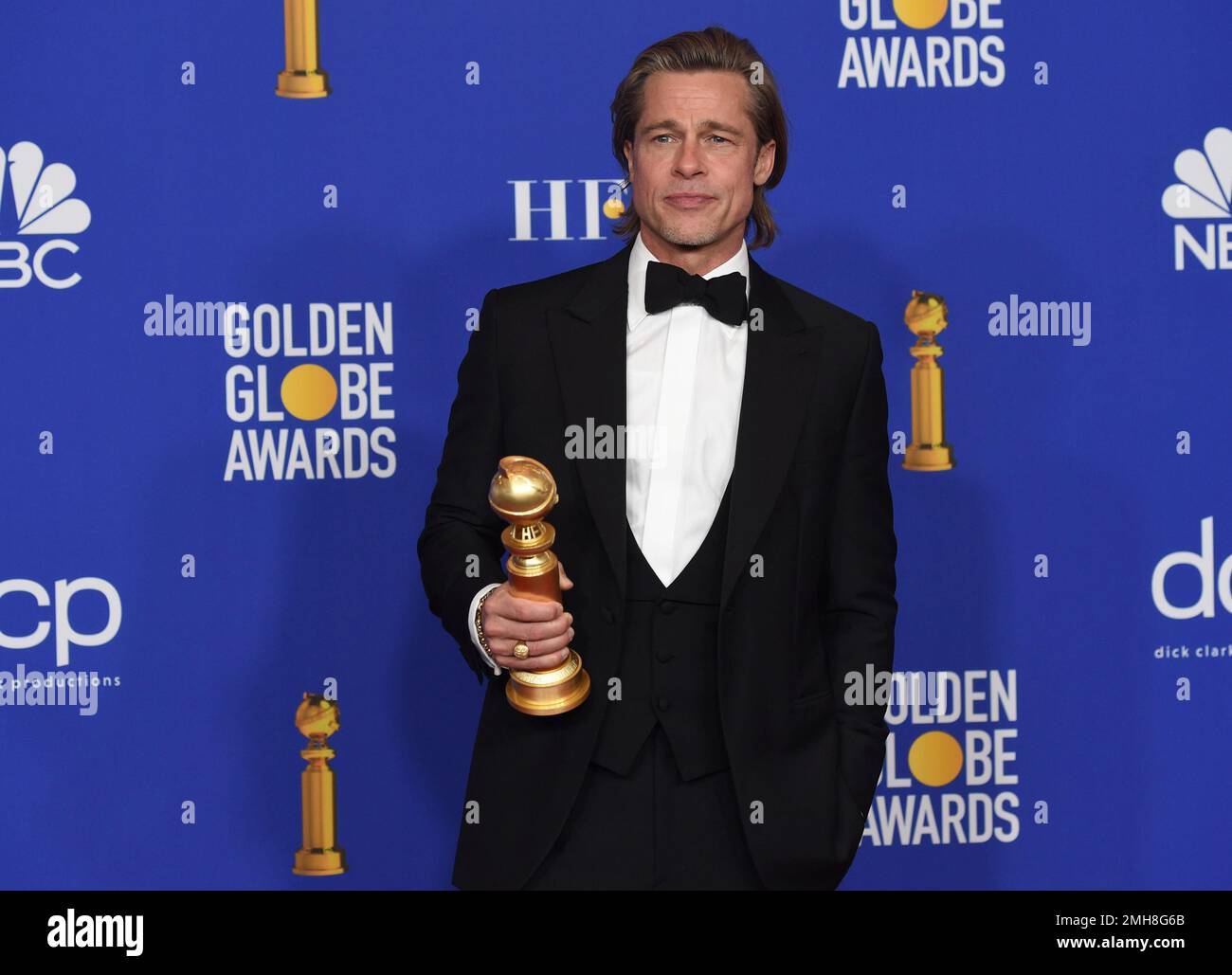 Brad Pitt poses in the press room with the award for best performance ...