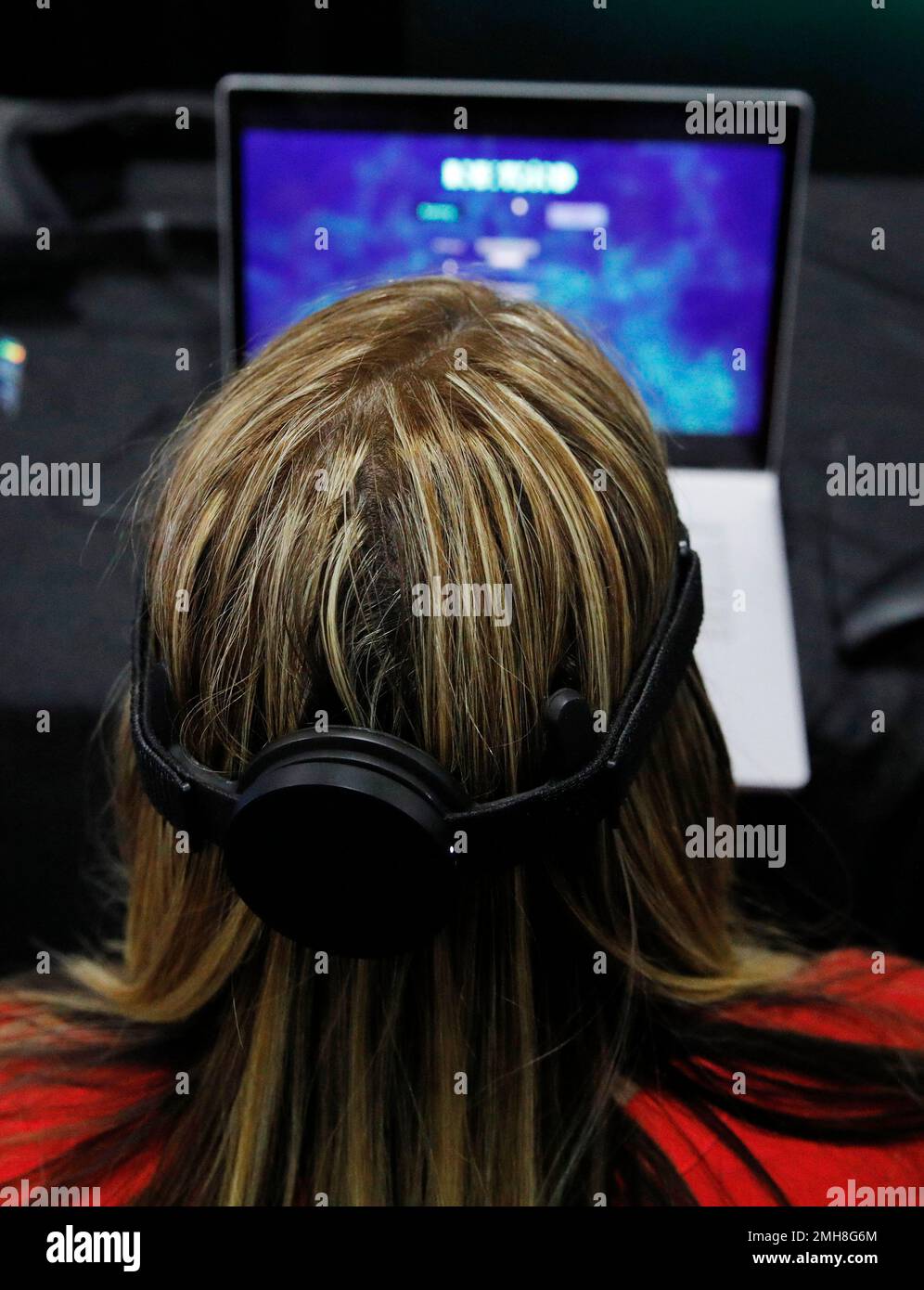 A woman uses the NextMind hands-free brain-computer interface device at ...