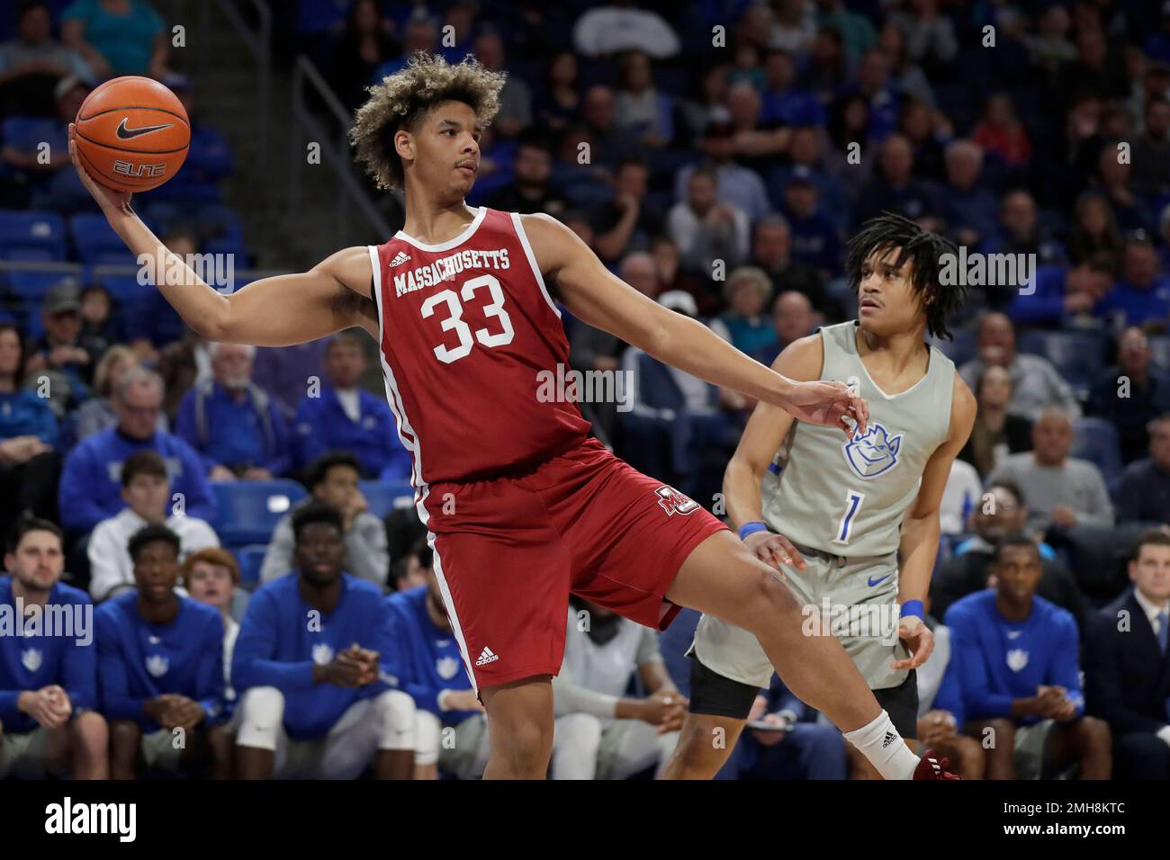 Massachusetts' Tre Mitchell (33) saves a ball before it goes out of ...