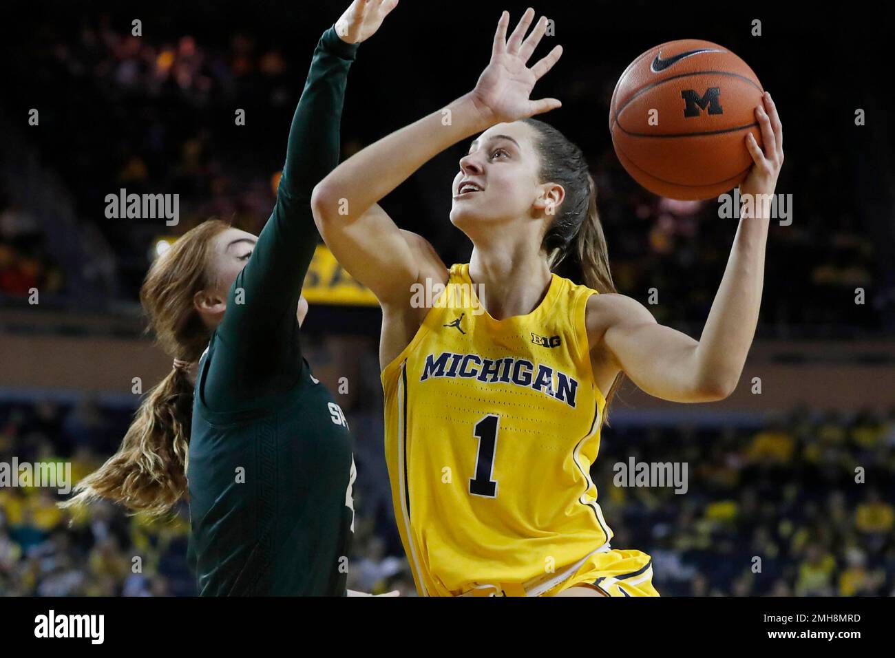 Michigan guard Amy Dilk (1) attempts a shot as Michigan State guard ...