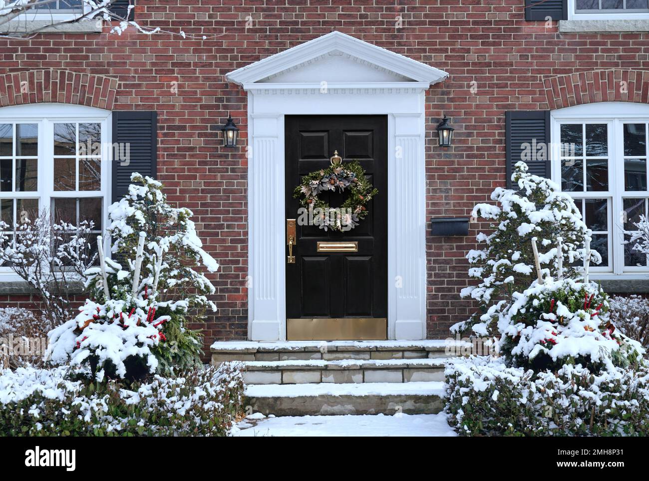 Traditional older brick house in winter with Christmas decoration on ...