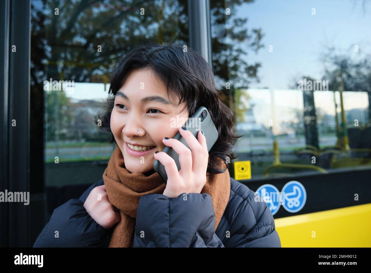 Cellular technology and people concept. Stylish asian girl talks on mobile phone, makes a ...