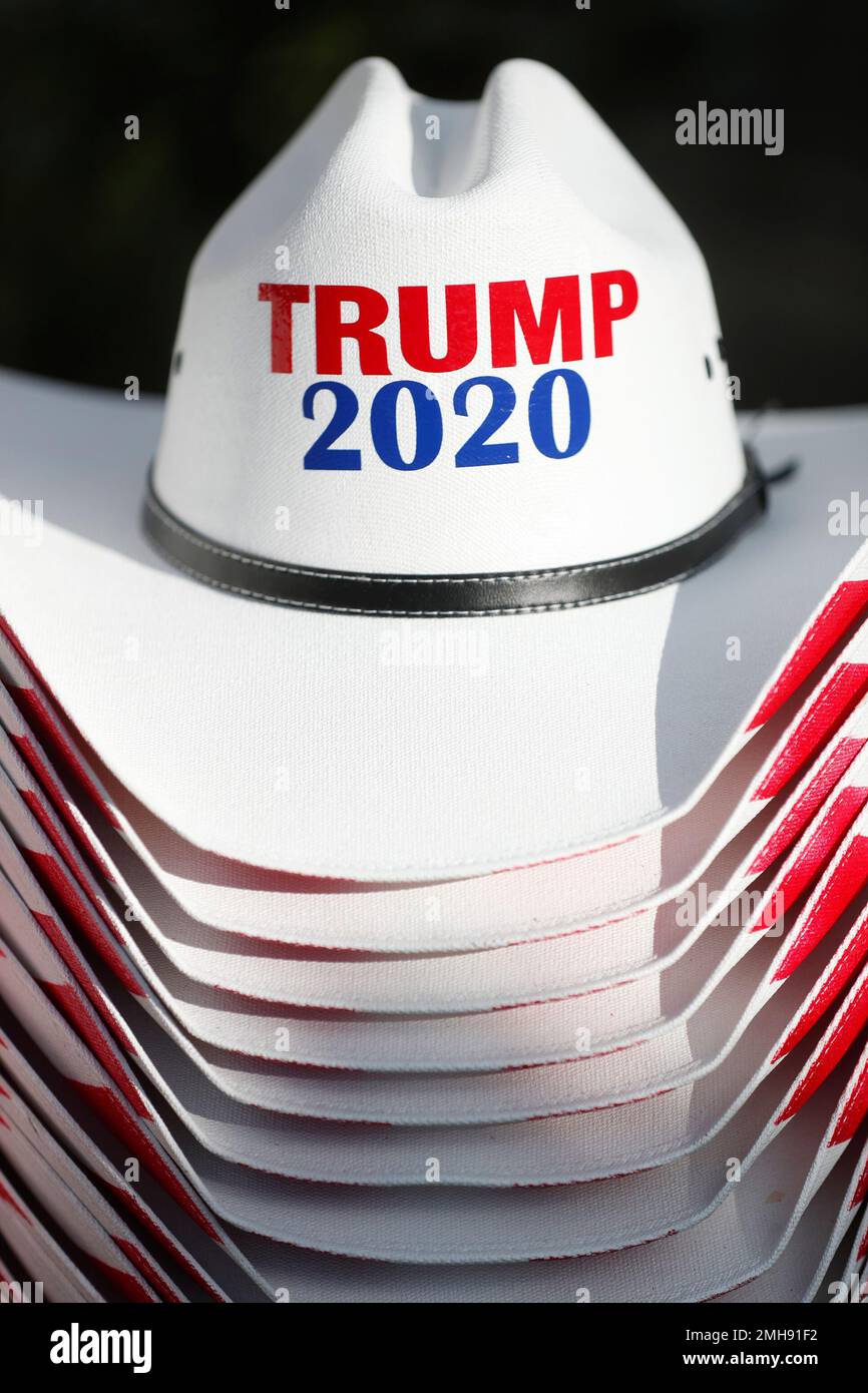 A stack of Trump 2020 hats are stacked at a vender's stall outside the ...