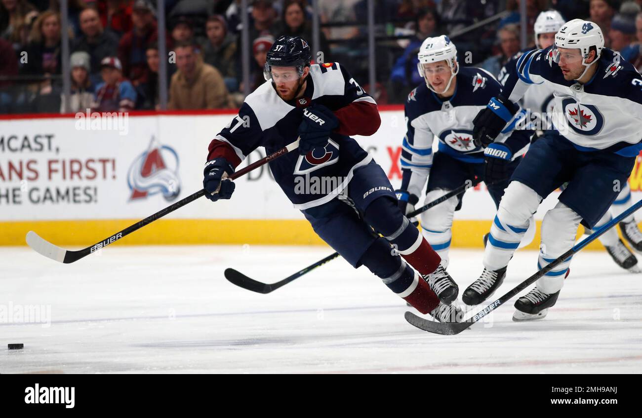 Colorado Avalanche left wing J.T. Compher, left, pursues the puck with ...