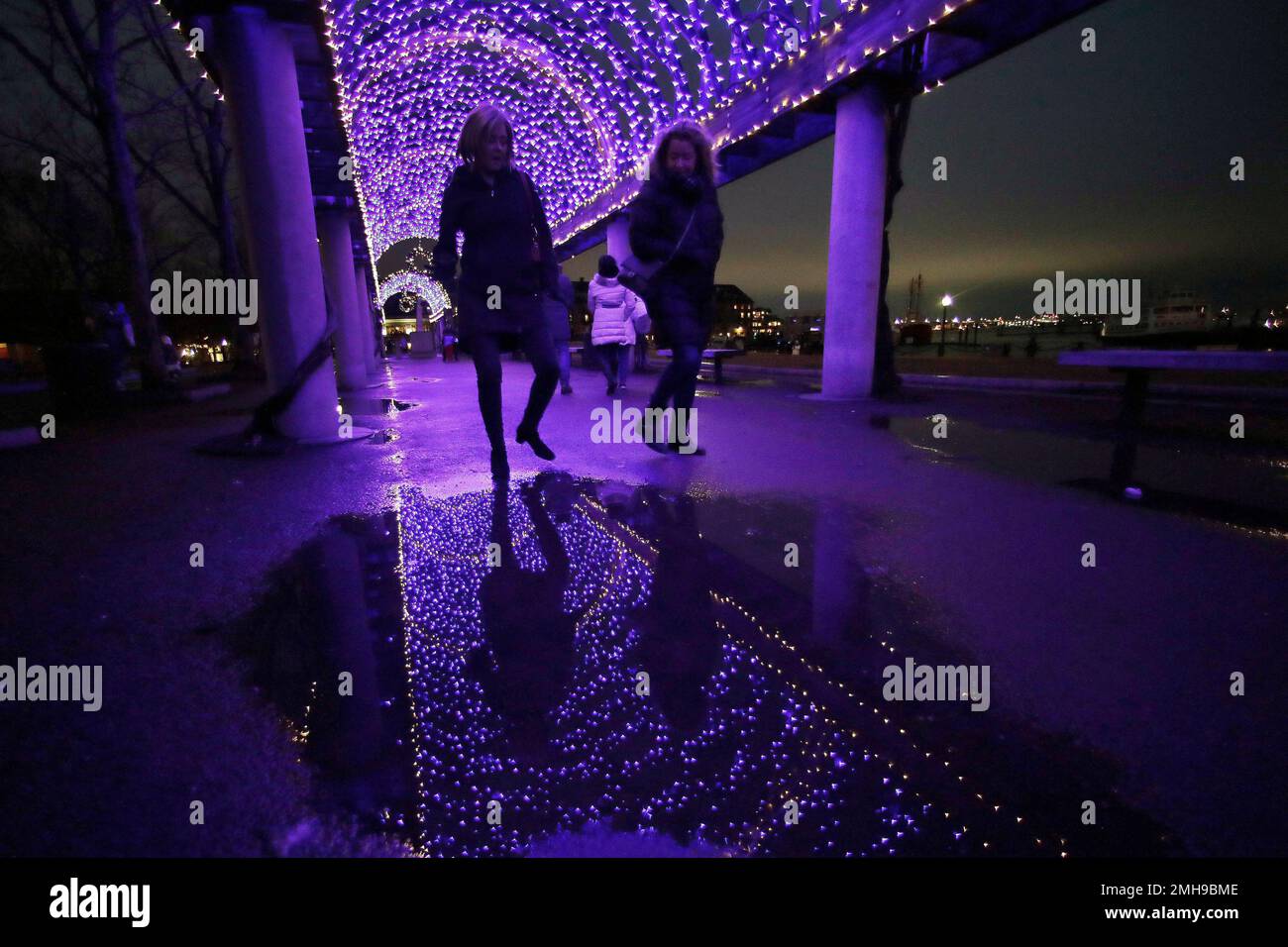 Two women stroll the Harborwalk, Friday, Dec. 31, 2019, in Boston ...