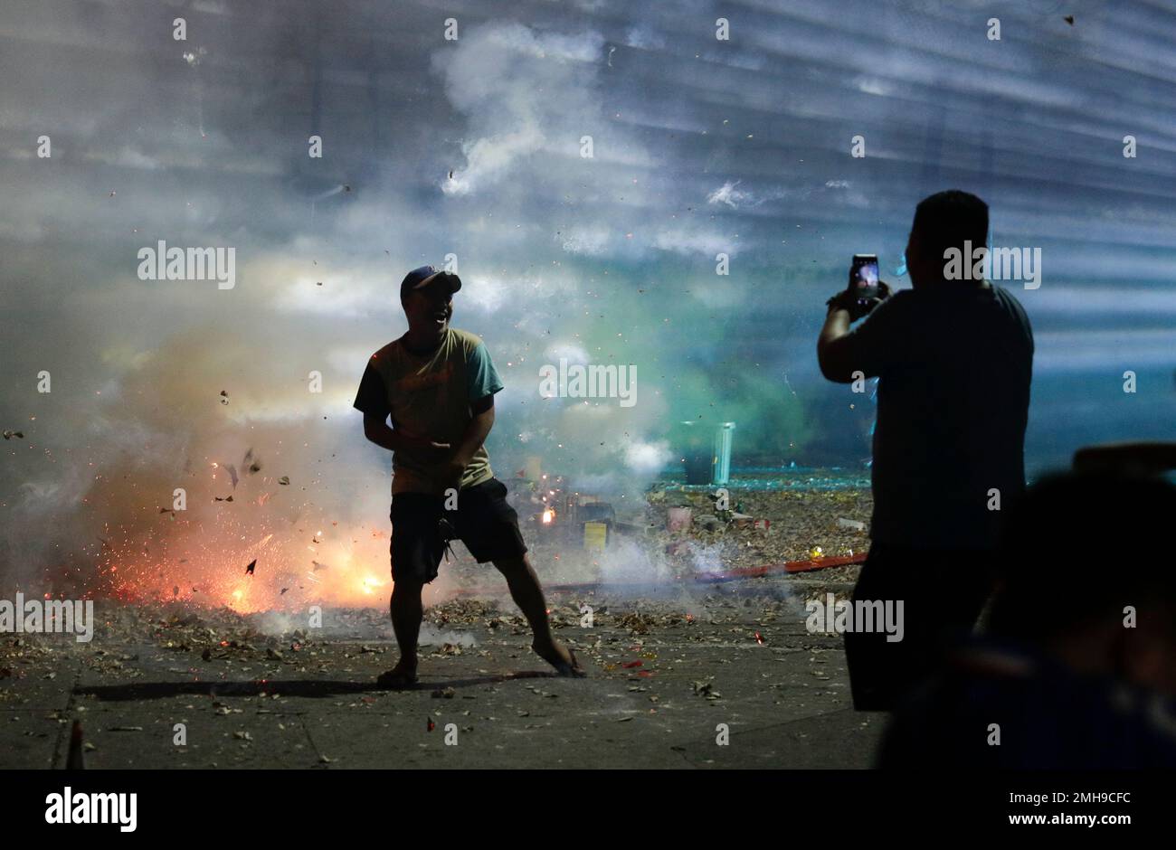 A Filipino poses for a selfie beside exploding firecrackers as they ...