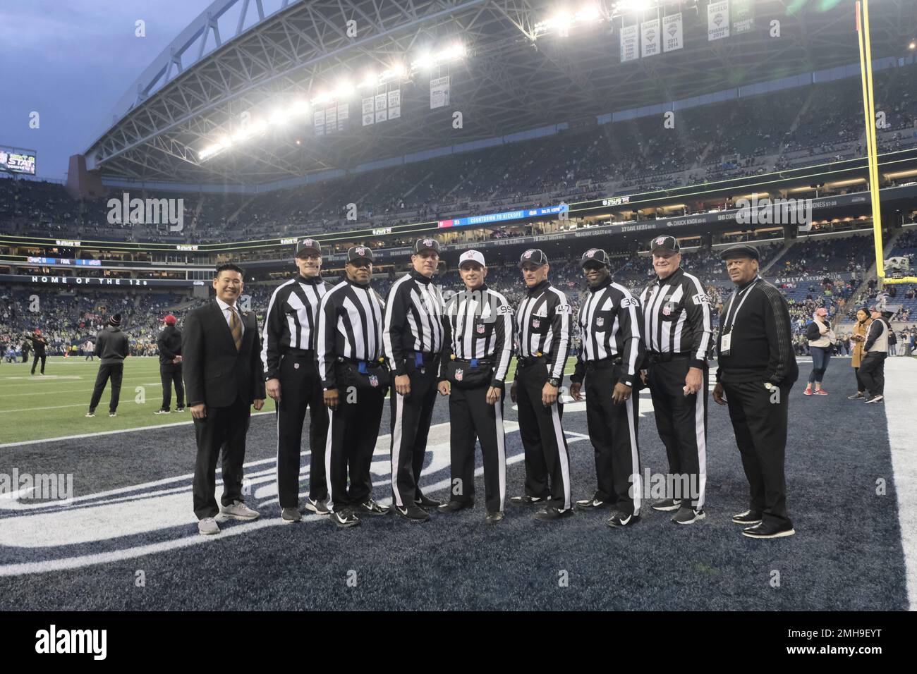 Officials wearing striped shirts, beginning second left, line judge ...