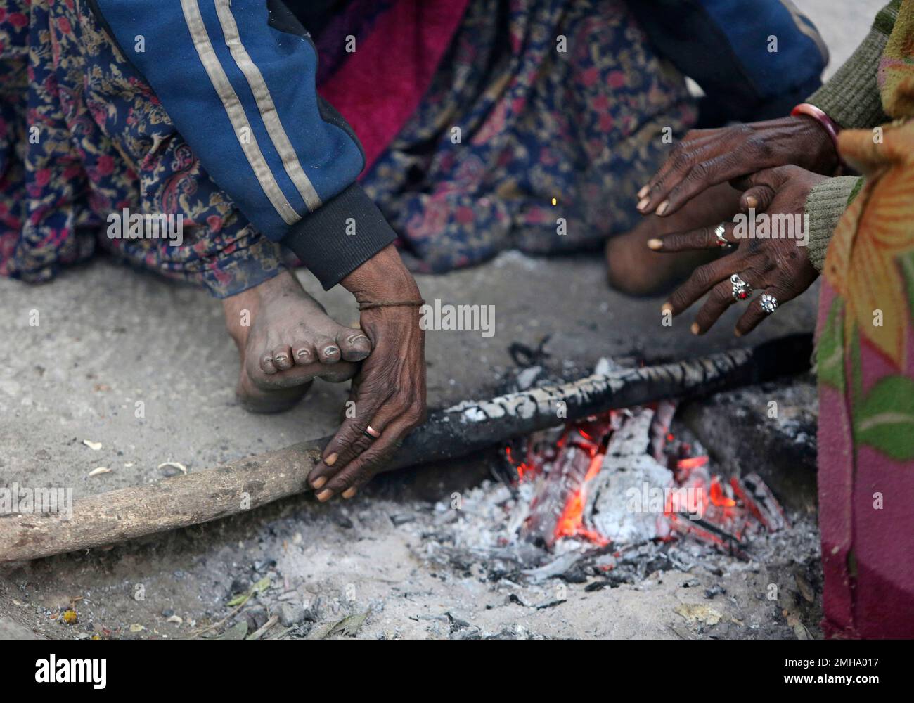 Homeless Indians warm themselves by a bonfire under an overpass in ...