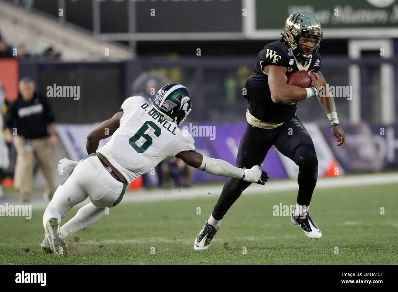 Wake Forest's Jamie Newman, right, runs past Michigan State's David ...